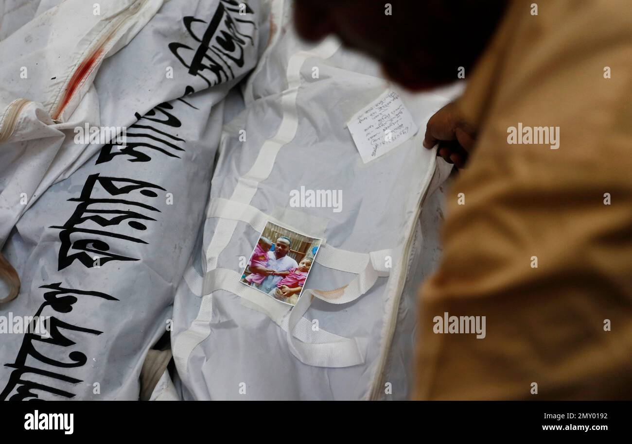 A photograph is placed on the body of a fire victim at a makeshift ...