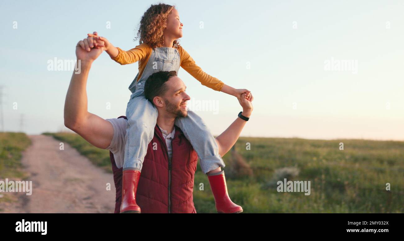 Happy, father and child on shoulders in the countryside enjoying quality bonding time together ...