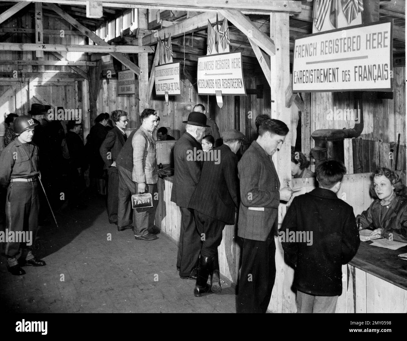 Displaced people register at desks marked with signs of various ...