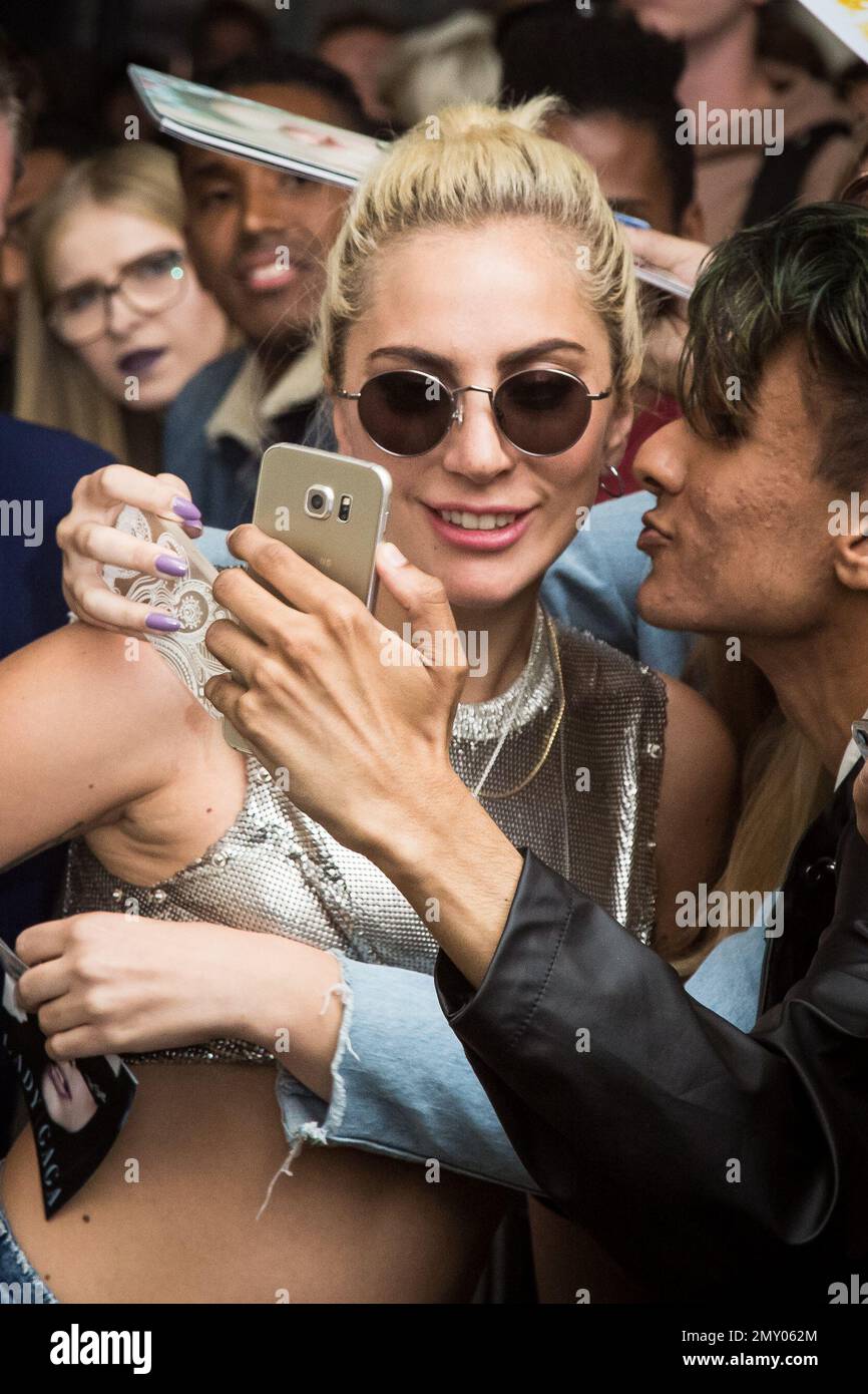 Singer Lady Gaga poses for photographs with fans as she leaves the BBC ...