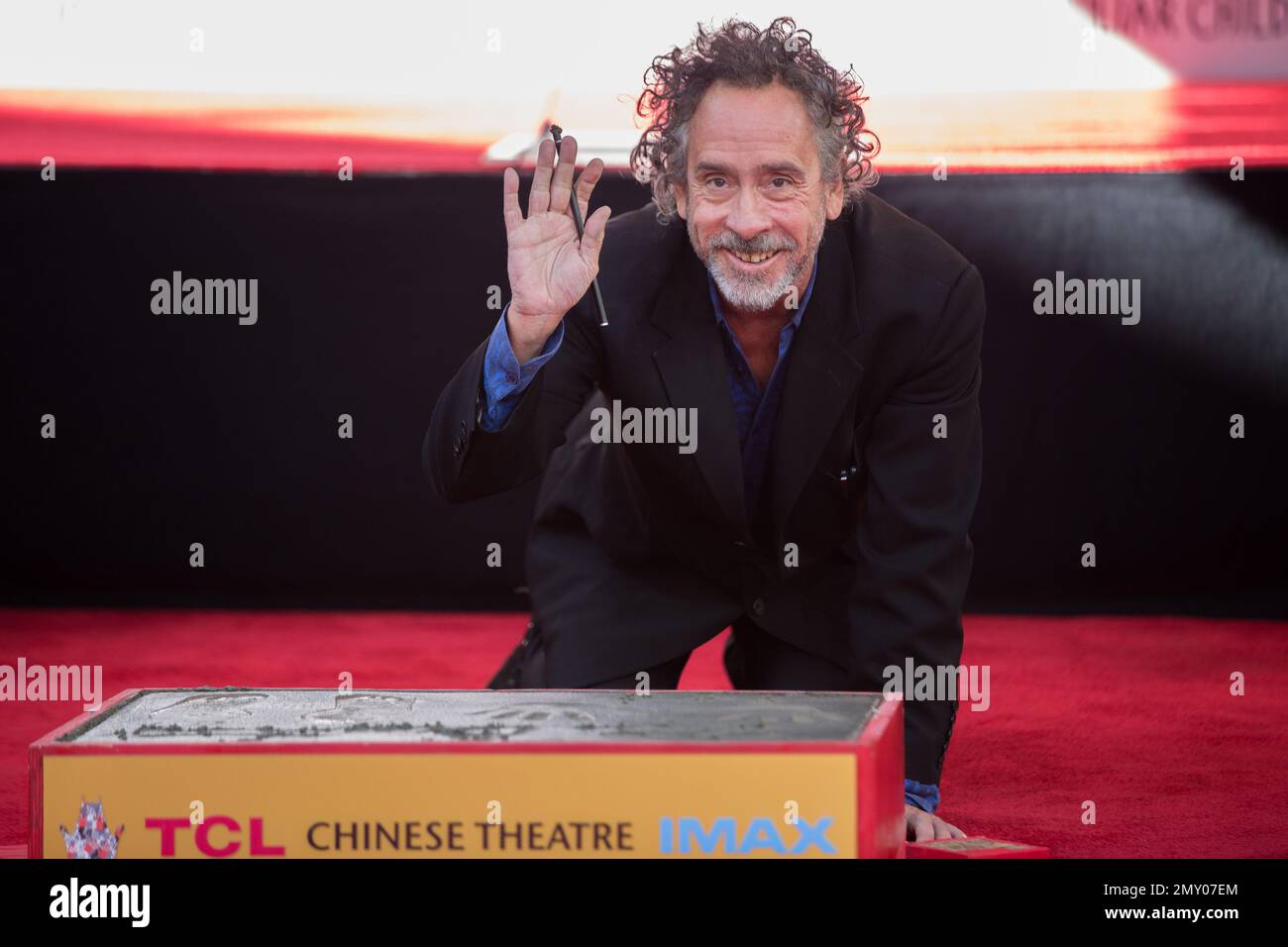 Tim Burton signs his name in wet cement at his hand and footprint ...