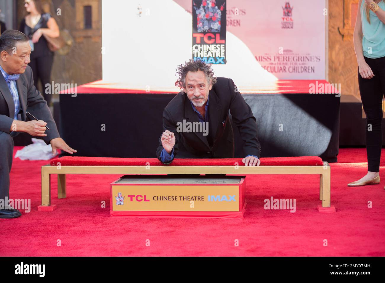 Tim Burton signs his name in wet cement at his hand and footprint ...