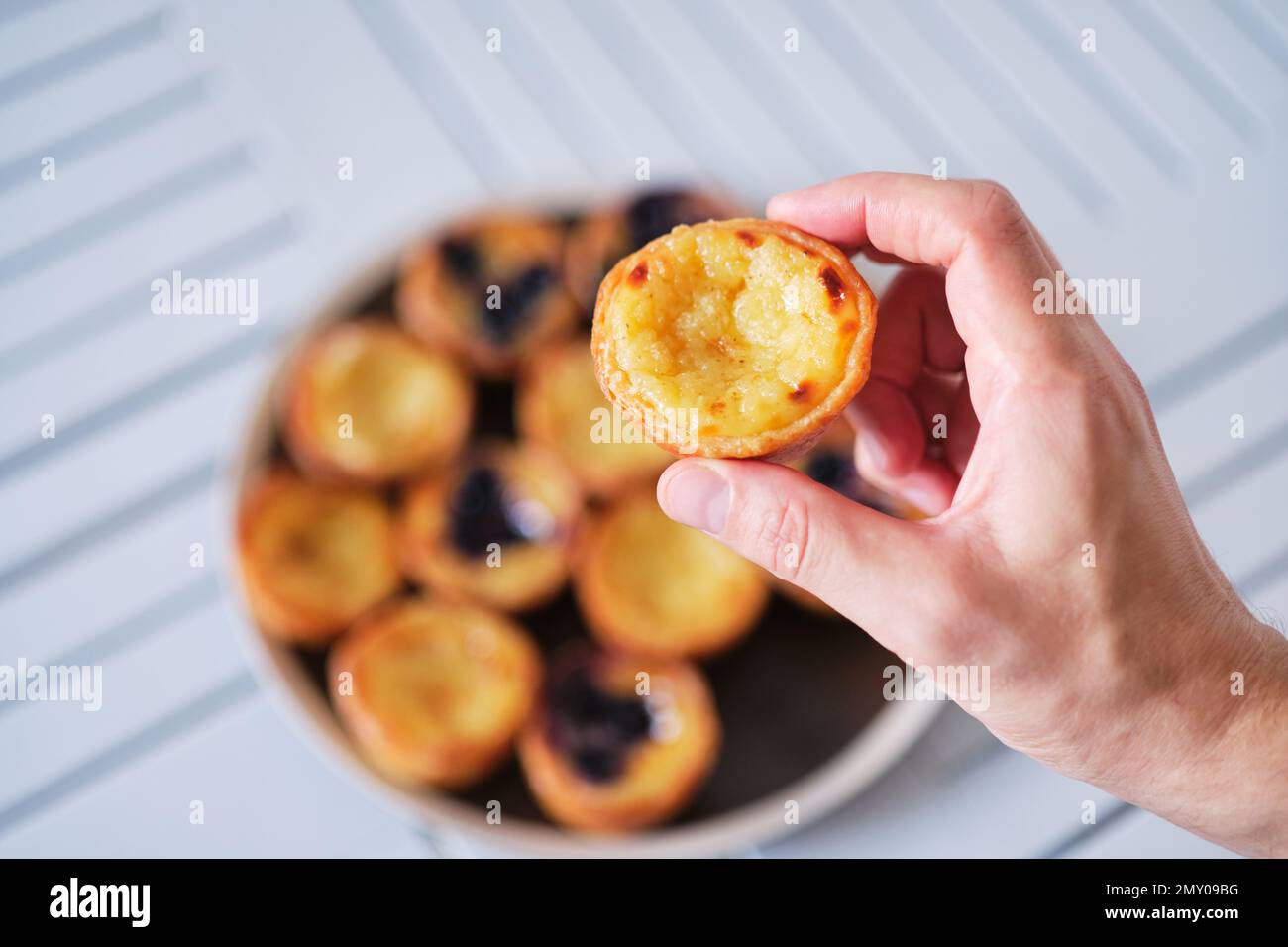Hand holding Belem cakes or Pasteis de Belem, Portuguese pastel de Nata ...