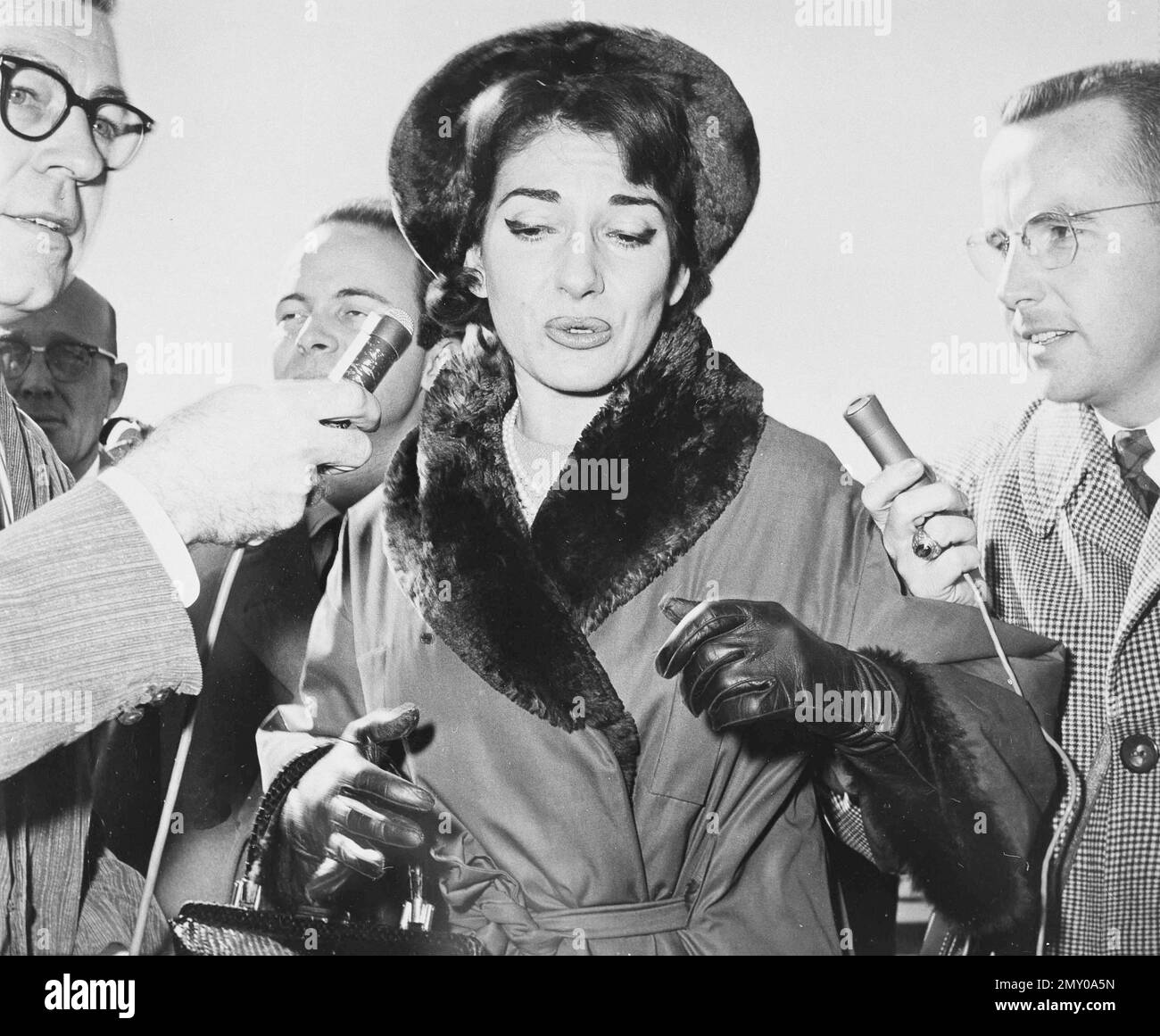 Soprano Maria Callas, brushes newsmen aside as she arrives in Dallas ...