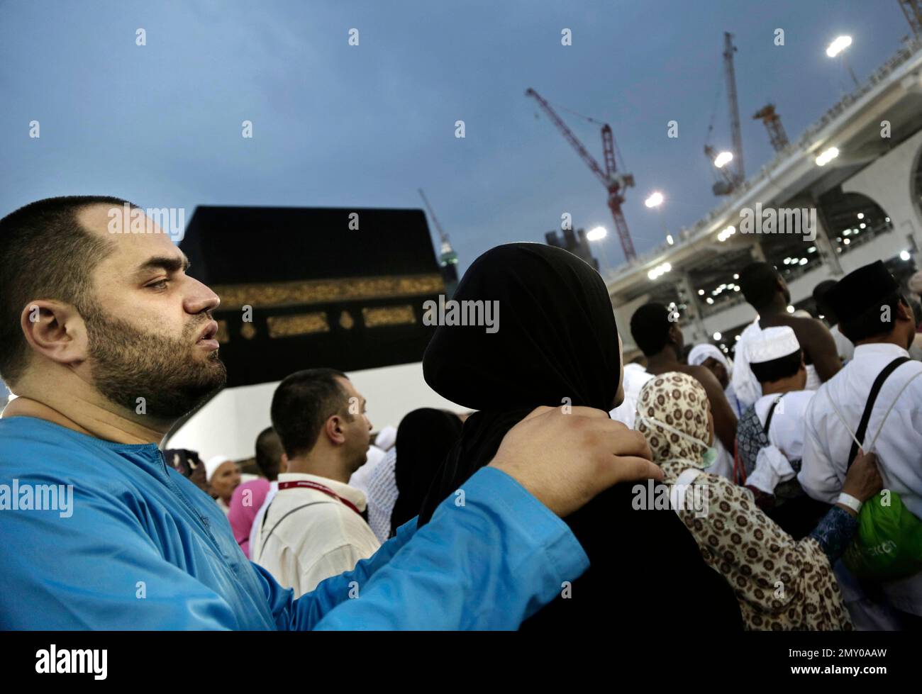 A man holds his wife as they circle the Kaaba, Islam's holiest shrine ...