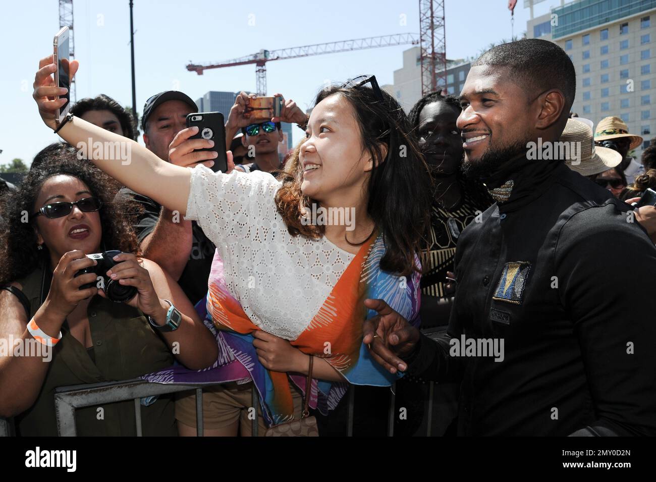 Usher poses for photos with fans at a ceremony honoring him with a star ...