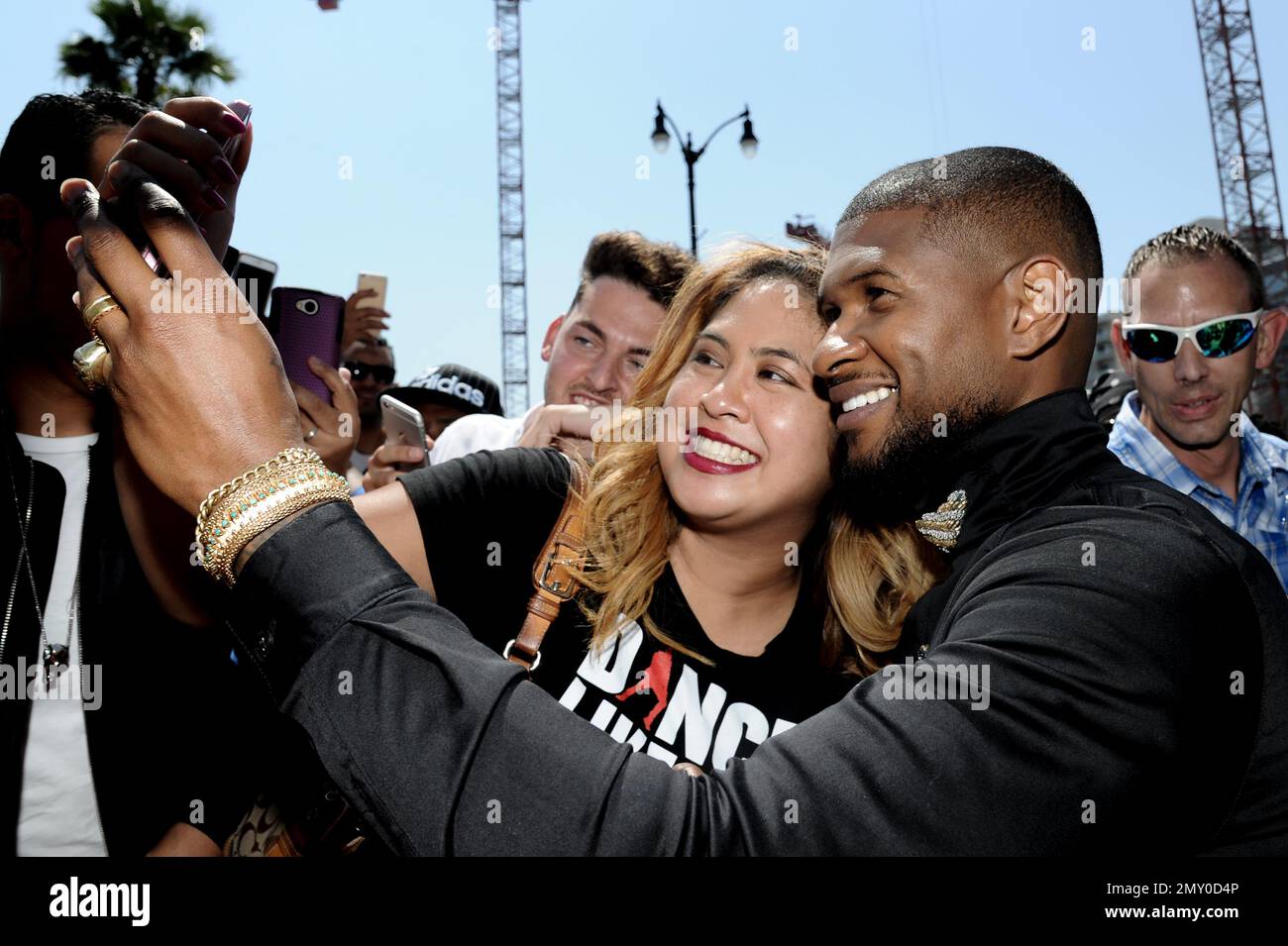 Usher poses for photos with fans at a ceremony honoring him with a star ...