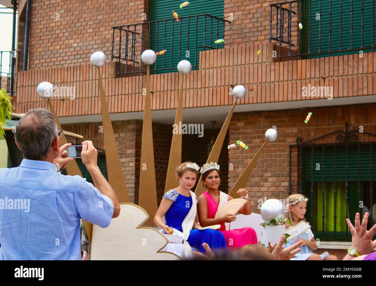 Party queens throwing sweets from a float during the annual Assumption ...