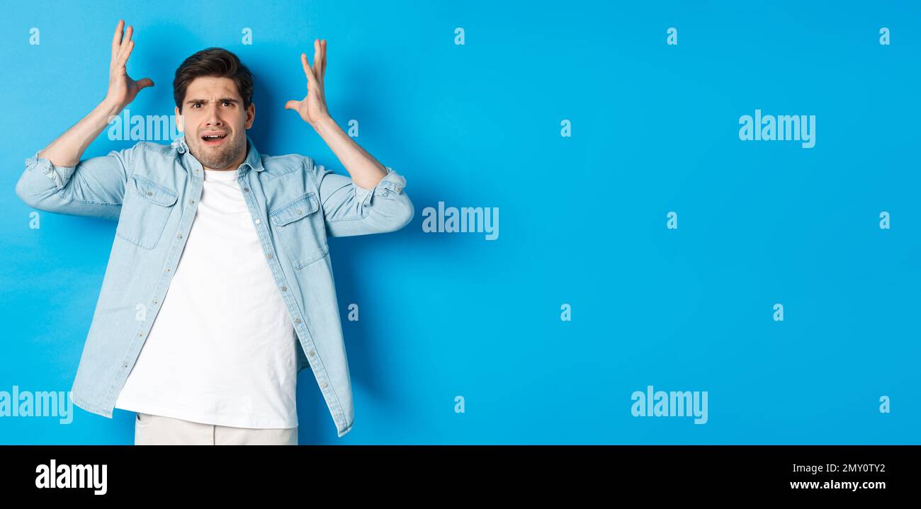 Confused and bothered man holding hands near head, looking frustrated ...