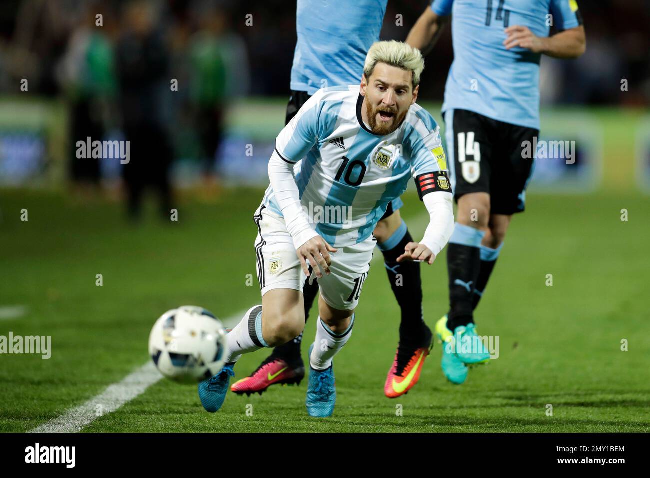 Argentina's Lionel Messi falls after being fouled by Uruguay's Gaston ...