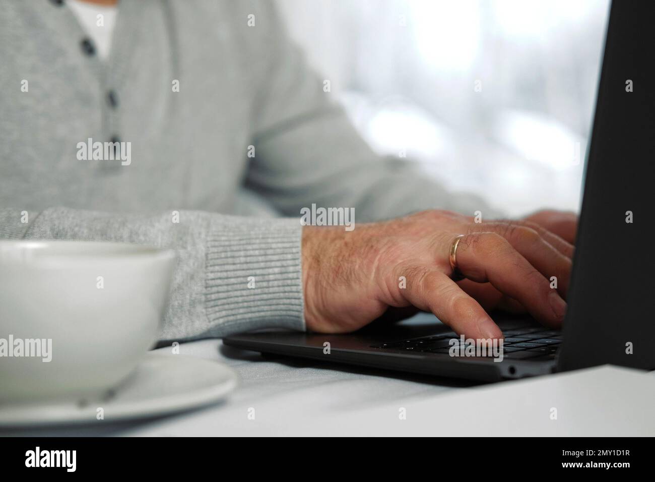 Closeup of senior man hands using laptop. Cropped side view of wrinkled ...
