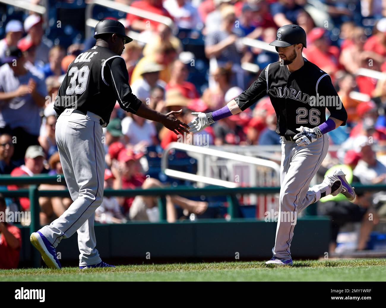 Colorado Rockies' David Dahl is greeted by third base coach Stu Cole ...