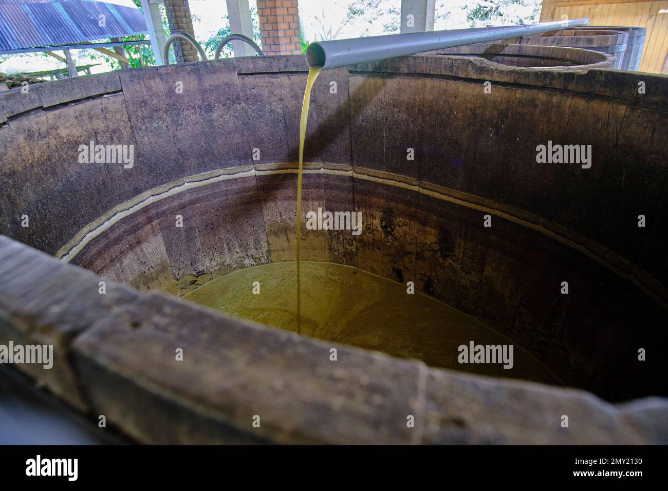 Part of the traditional process of distilling brandy from sugar cane, a ...