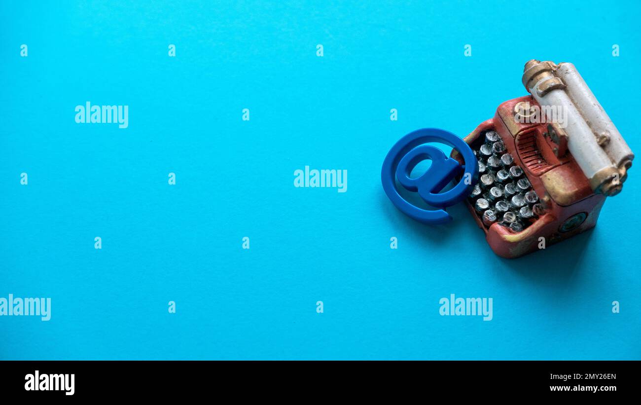 Email icon or symbol with a miniature typewriter on a blue background ...