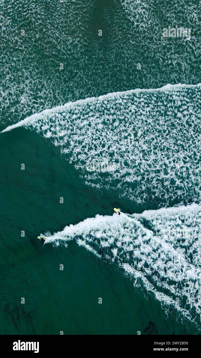 A vertical aerial view of foamy waves on a green sea surface Stock ...