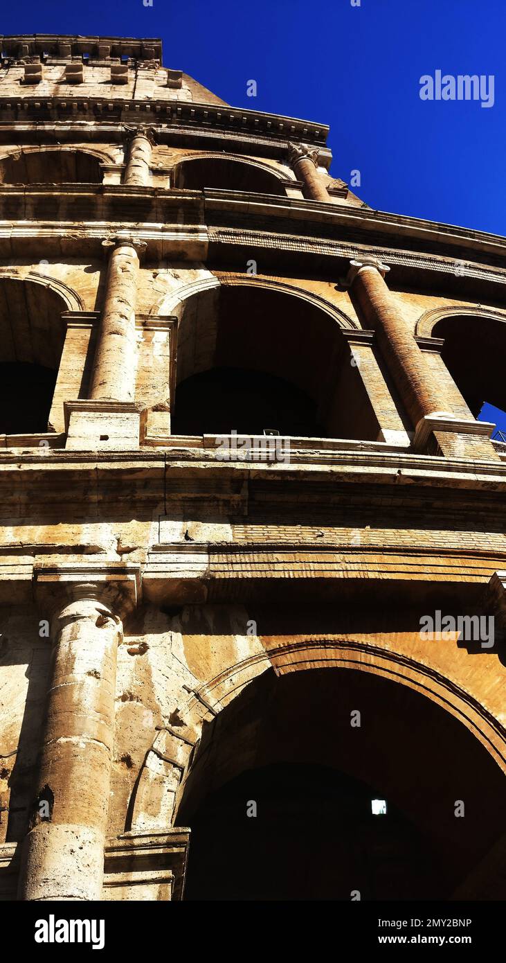 A vertical low angle shot of the historic Colosseum building in Rome ...