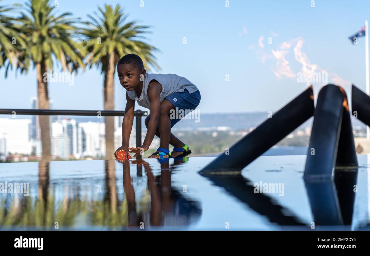 A kid playing with his reflection on the water in Perth, Western ...