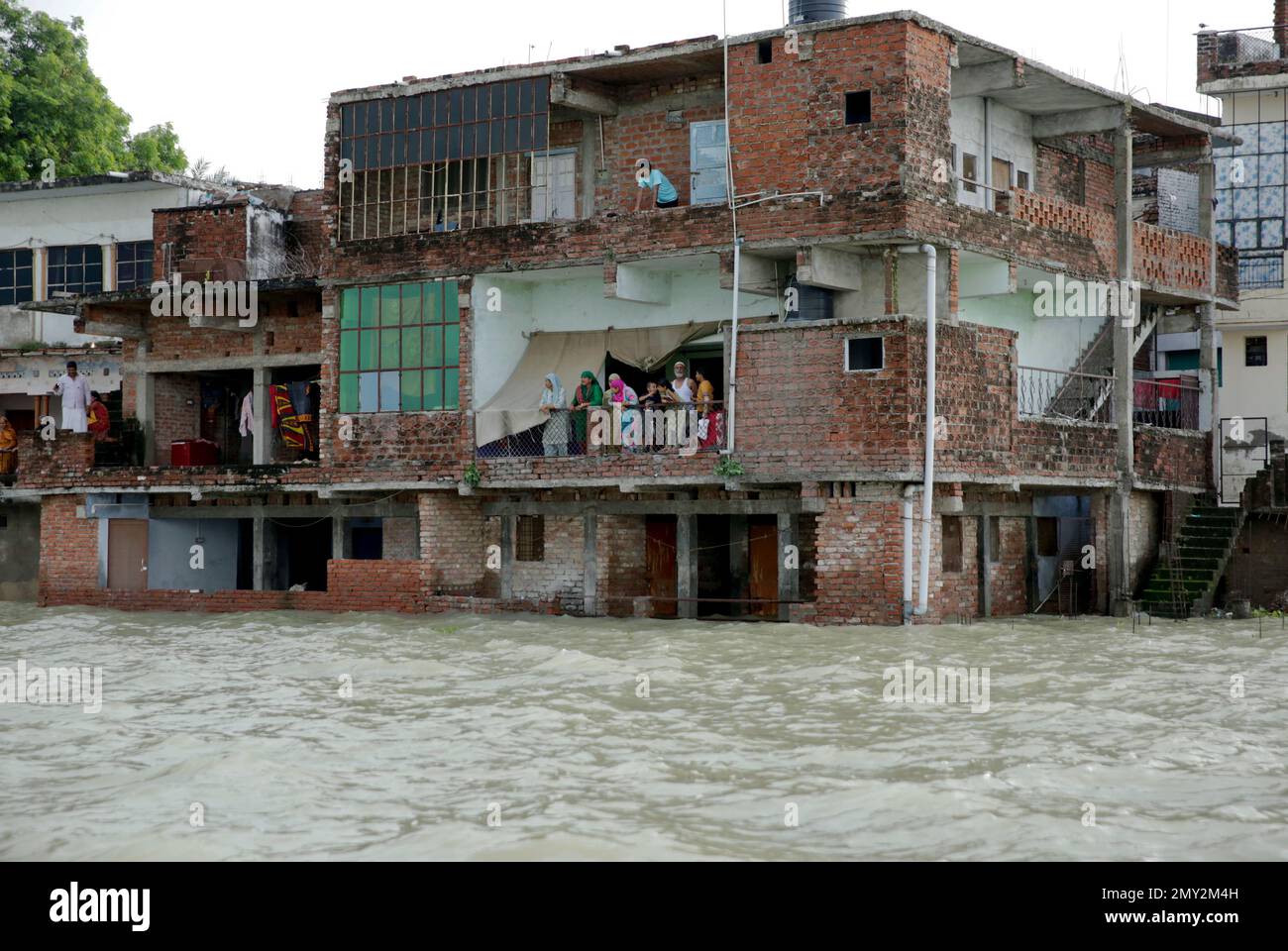 Indians look at the flooded river Ganges from their houses in Allahabad ...