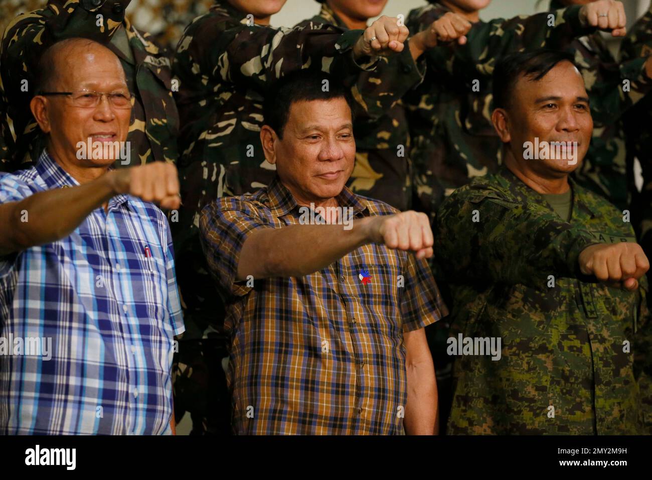 Philippine President Rodrigo Duterte, center, gestures with a fist bump ...