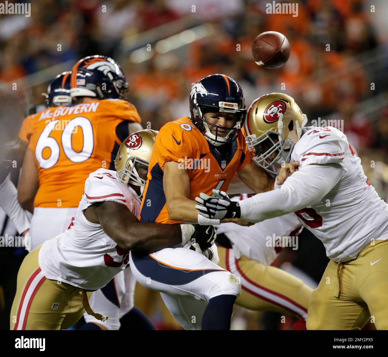 Denver Broncos quarterback Mark Sanchez, second from right, fumbles ...