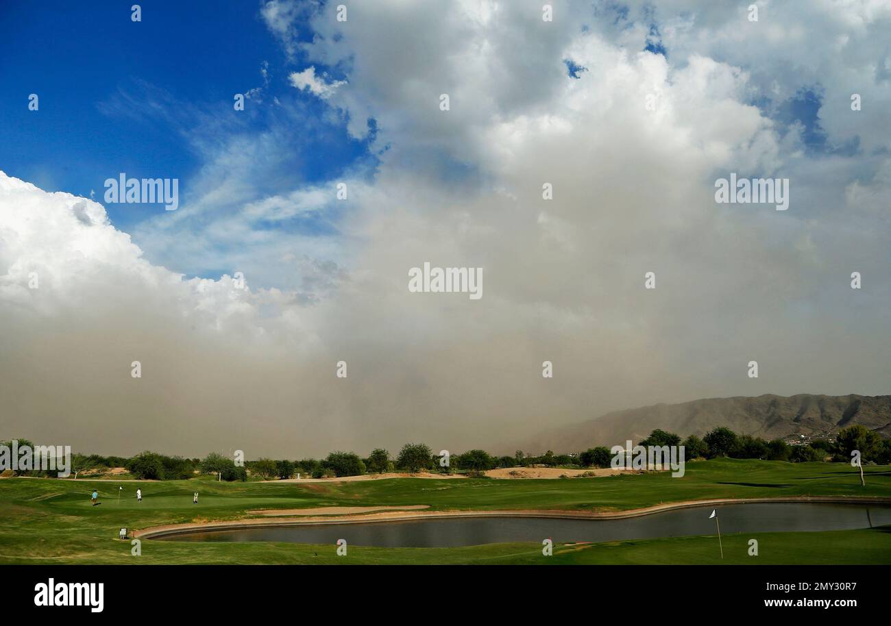 Golfers attempt to finish their round of golf as a giant dust storm ...