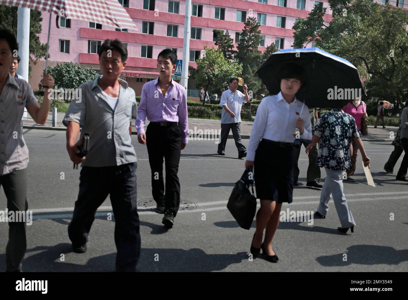 People cross a road in downtown Pyongyang, North Korea, Sunday, Aug. 21 ...