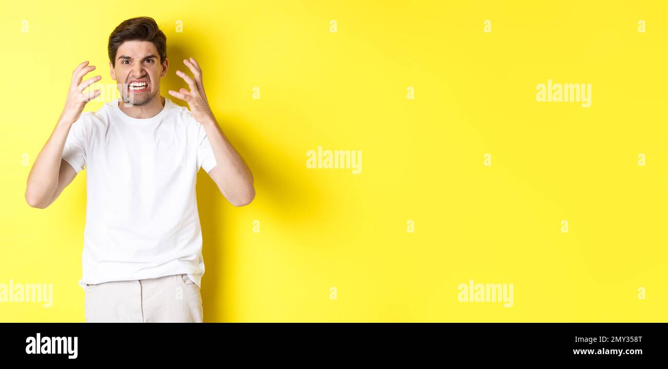 Angry man looking mad, grimacing and shaking hands furious, standing ...