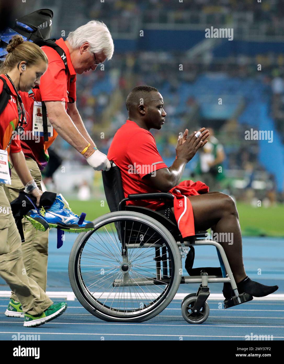 Kenya's Julius Yego is taken from the track in a wheelchair during the ...