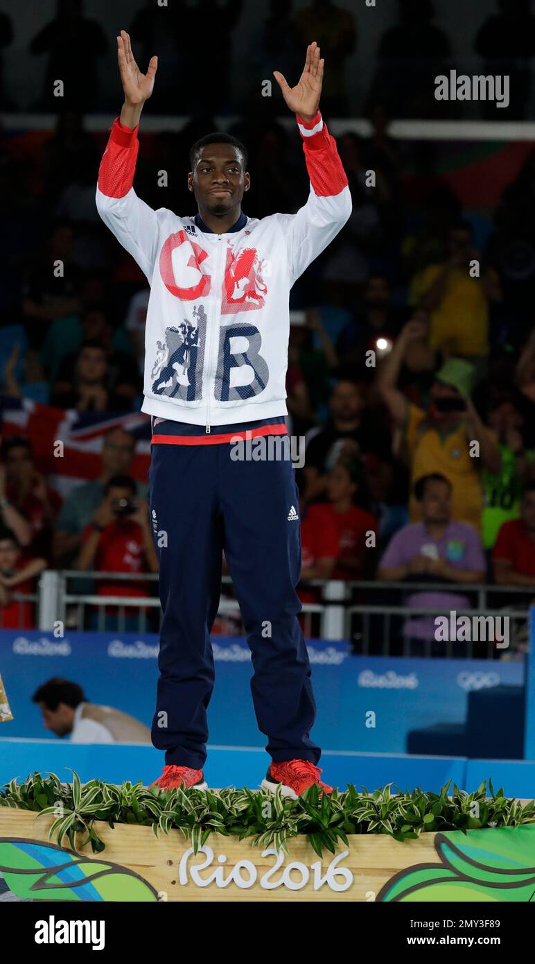 Lutalo Muhammad of Great Britain wears the silver medal on the podium ...
