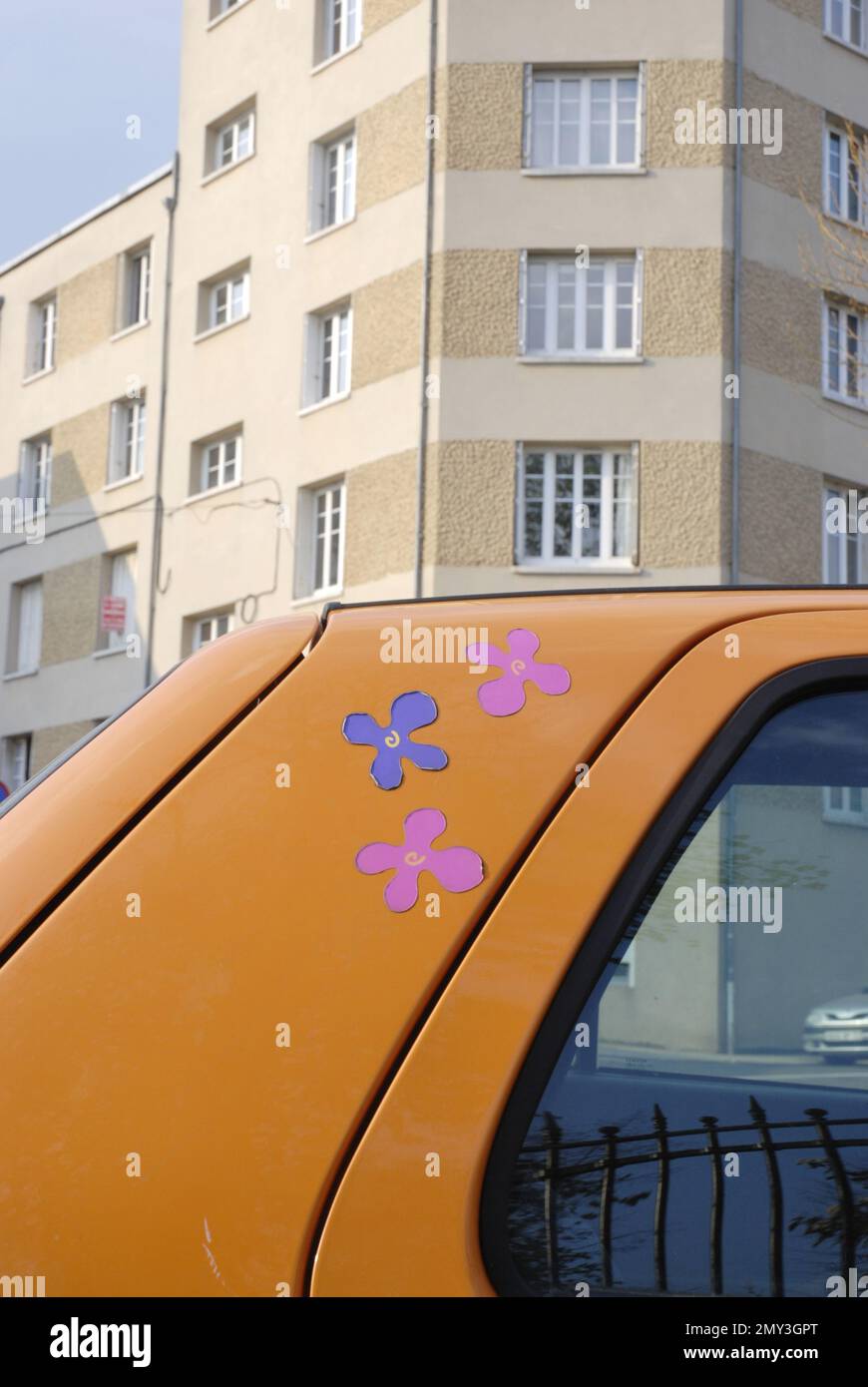colorful bumper stickers on an orange small car Stock Photo - Alamy