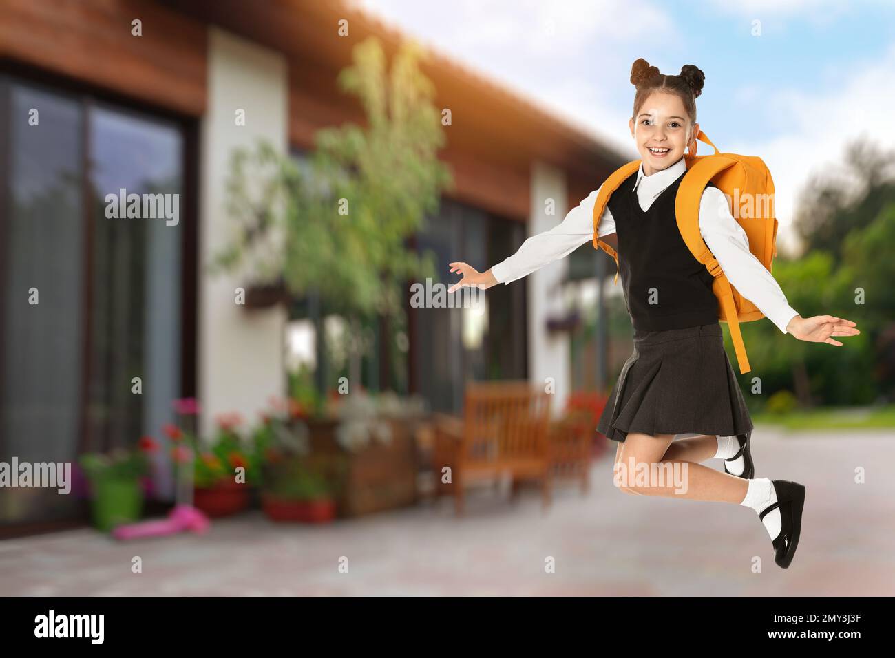 Happy girl jumping near house, space for text. School holidays Stock ...