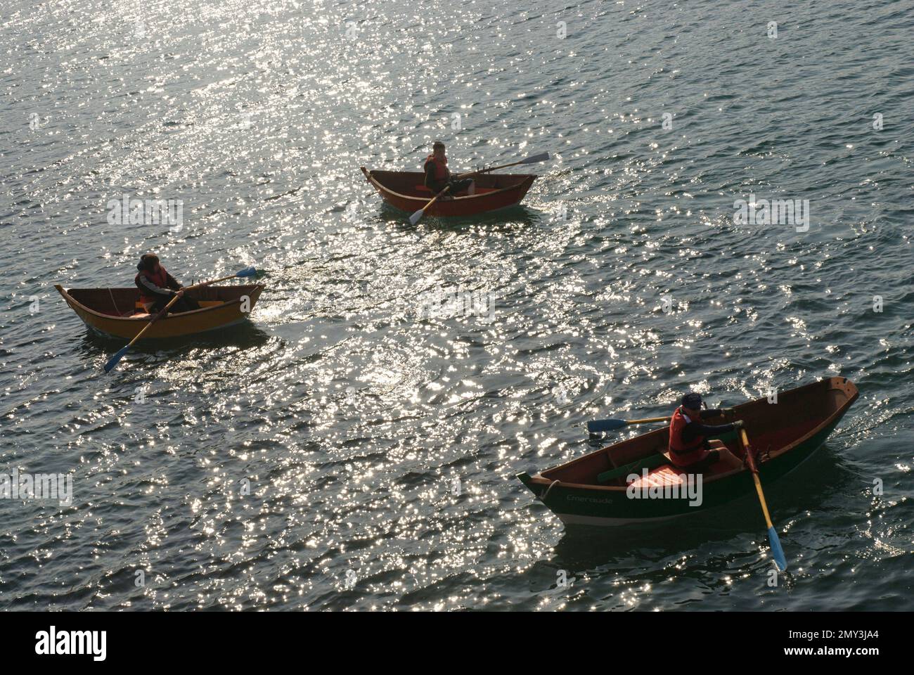 Three men in three boats are adrift on the open sea, rowing home Stock ...