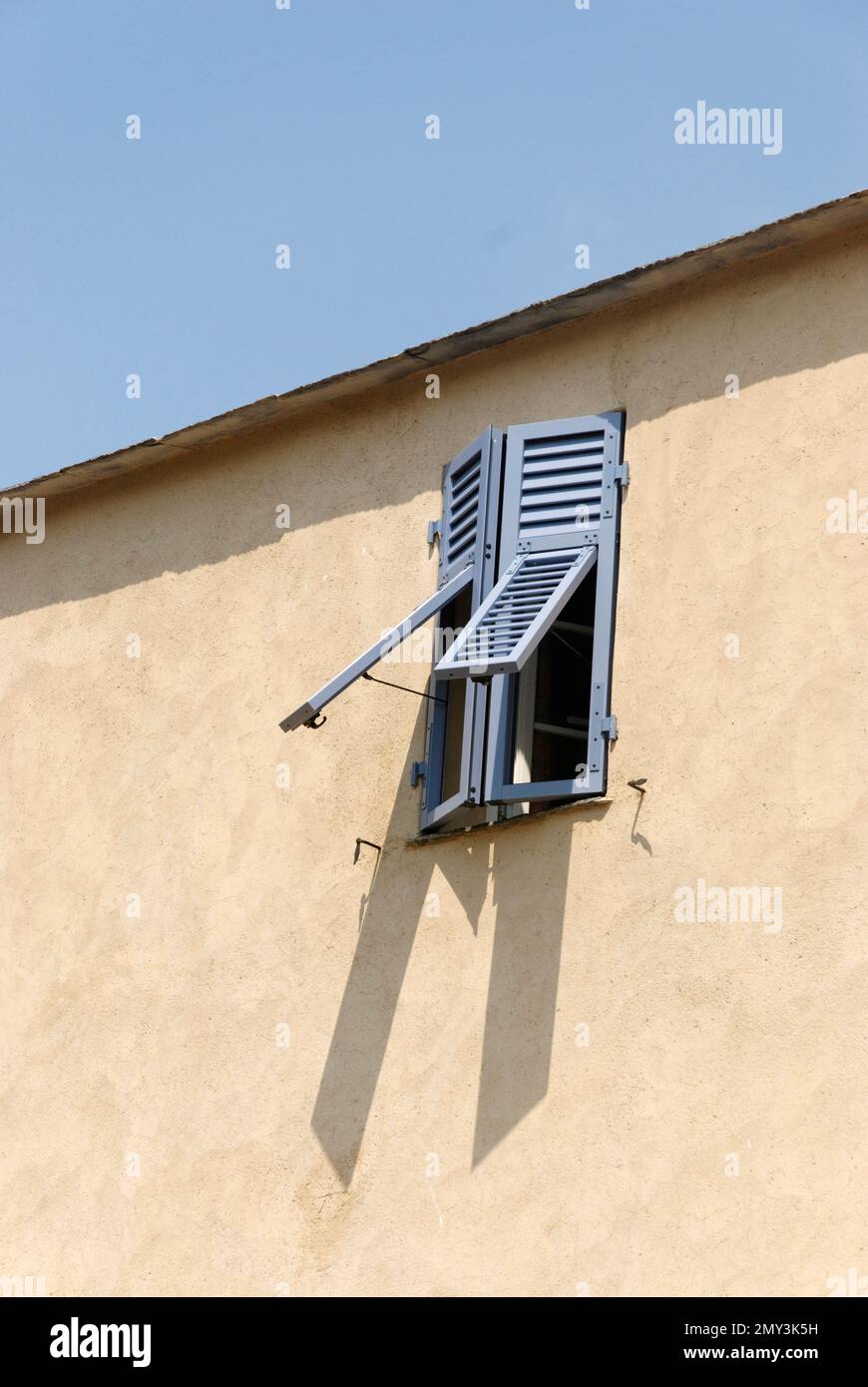a window with a folding shutter under the roof of a house Stock Photo ...