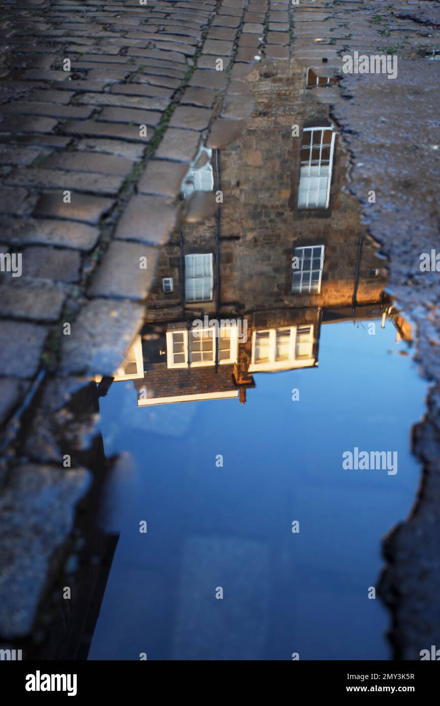 Building Reflected on water puddle Stock Photo - Alamy