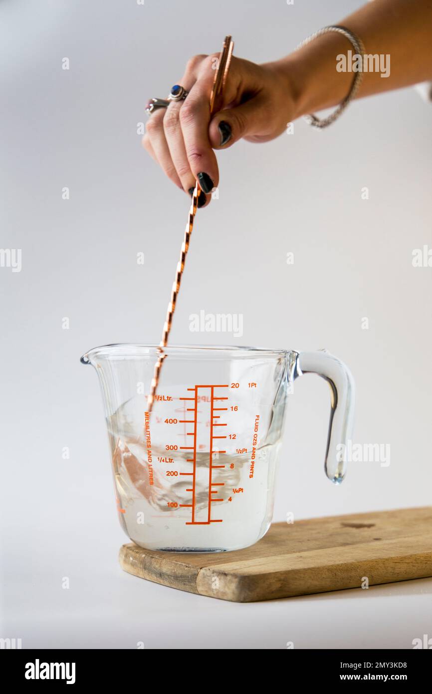 Hand of a girl mixing a transparent liquid on a measuring jug Stock ...
