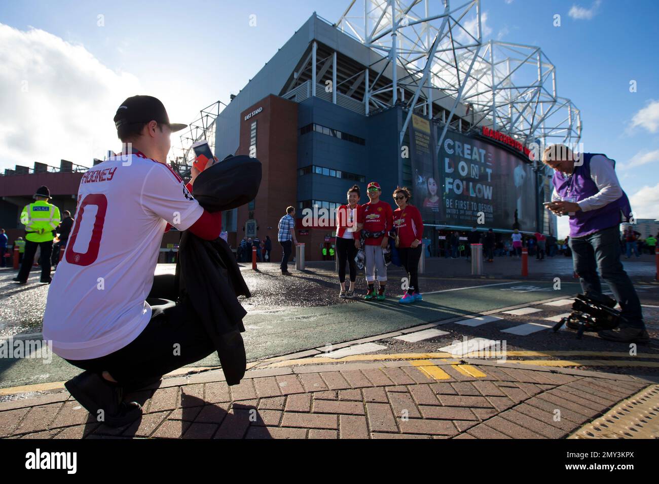 A supporter takes a photograph outside Old Trafford Stadium before the ...