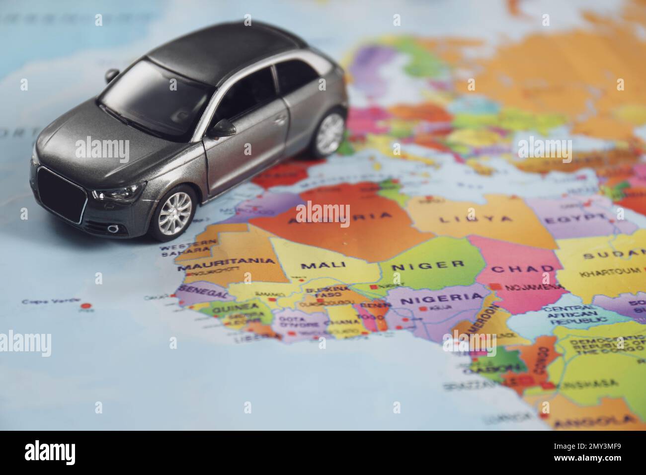 Grey toy car on world map. Trip planning Stock Photo - Alamy