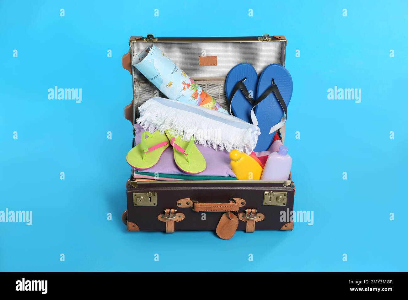 Open vintage suitcase with different beach objects packed for summer ...