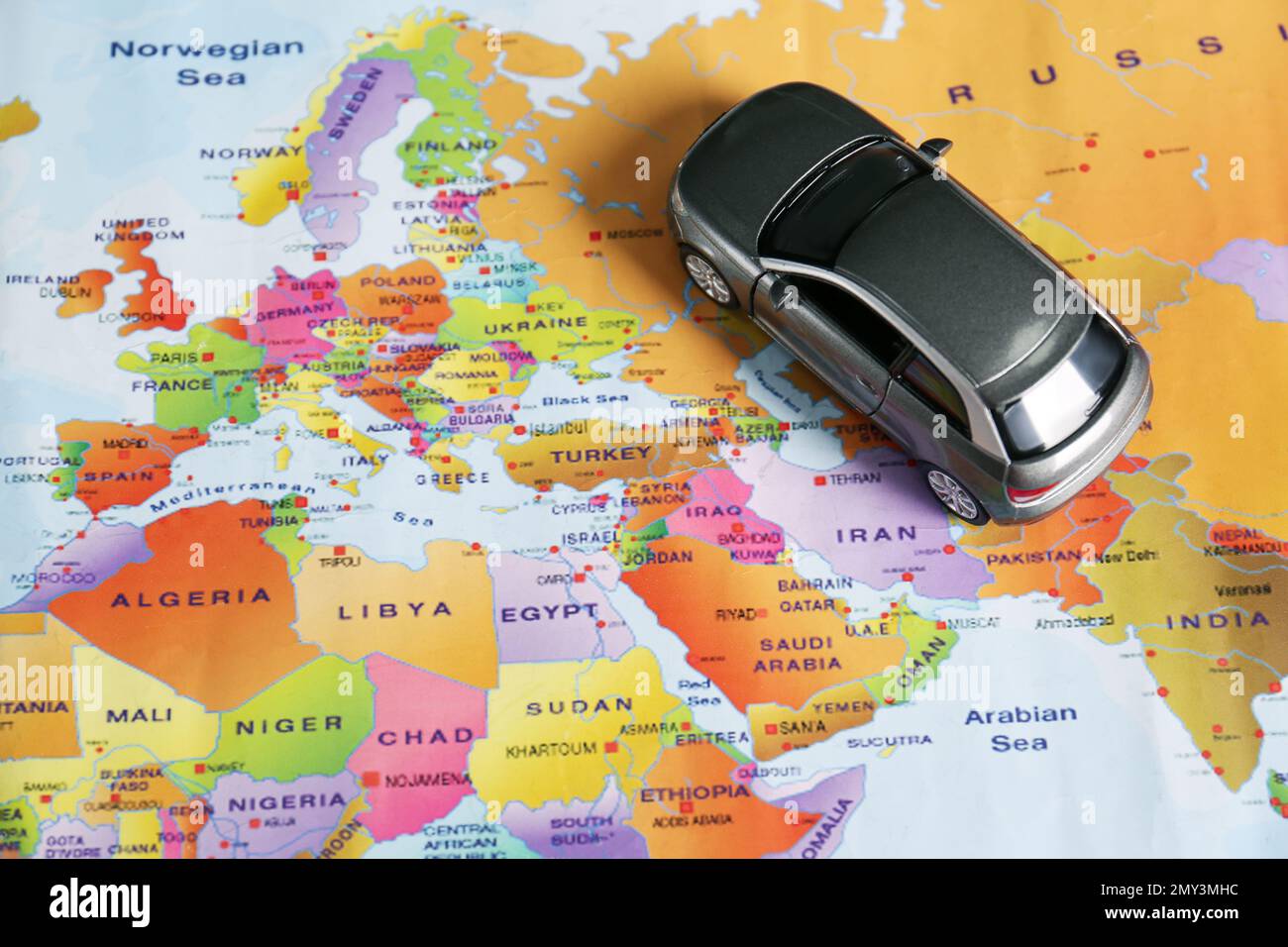 Grey toy car on world map. Trip planning Stock Photo - Alamy