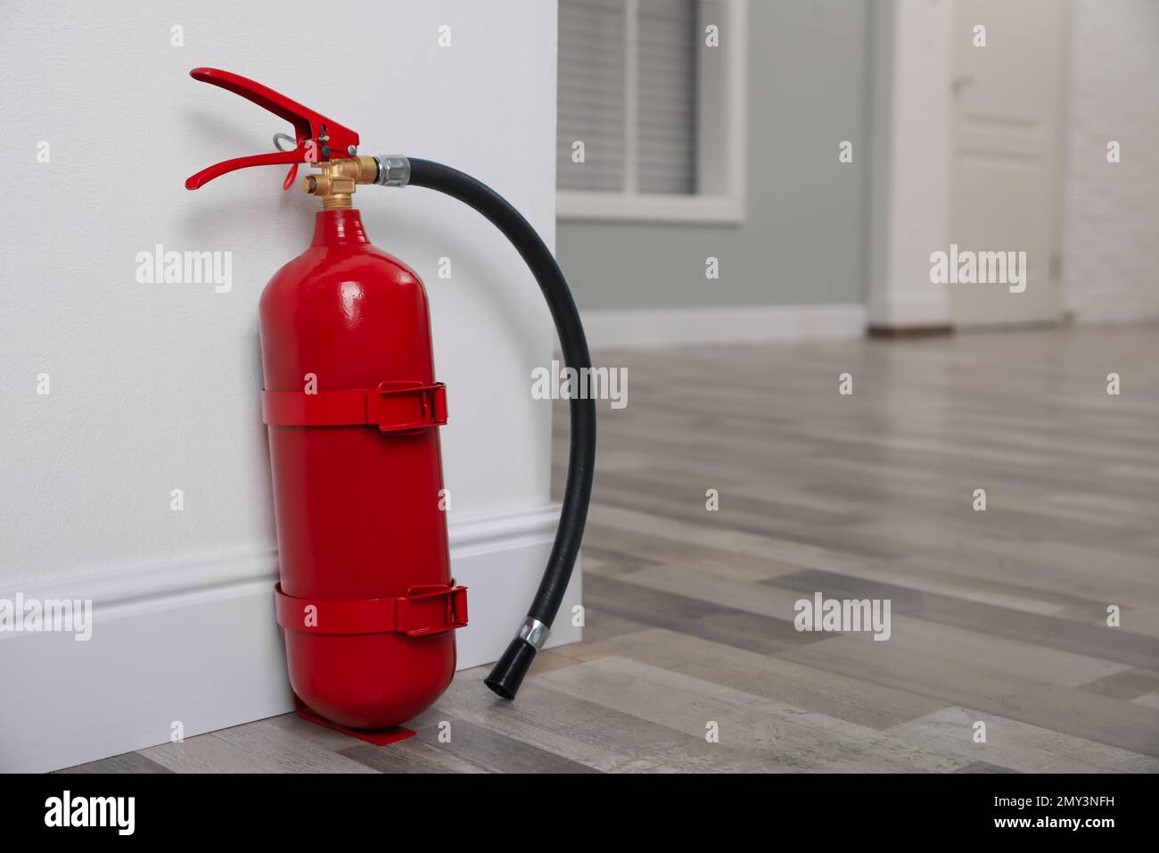 Fire extinguisher near white wall indoors. Space for text Stock Photo ...
