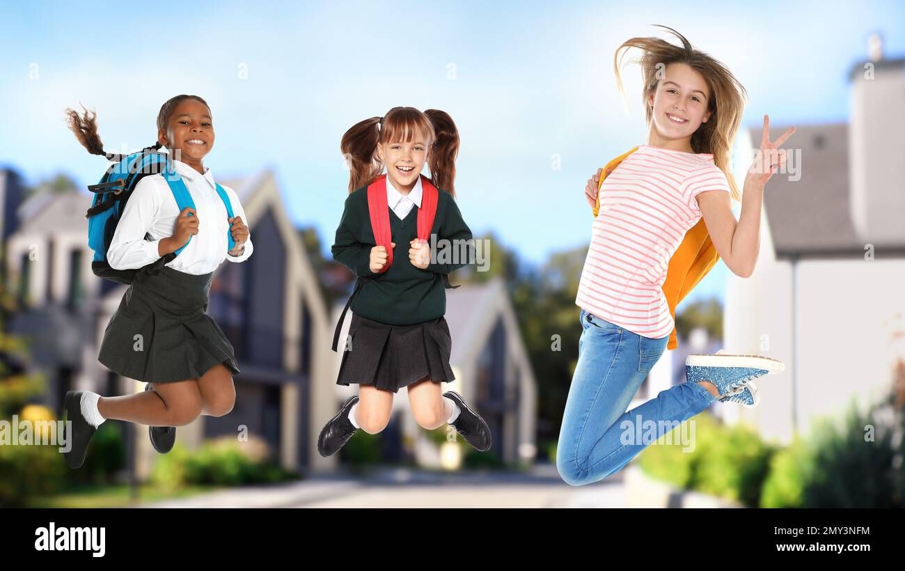 Happy girls jumping on street. School holidays Stock Photo - Alamy