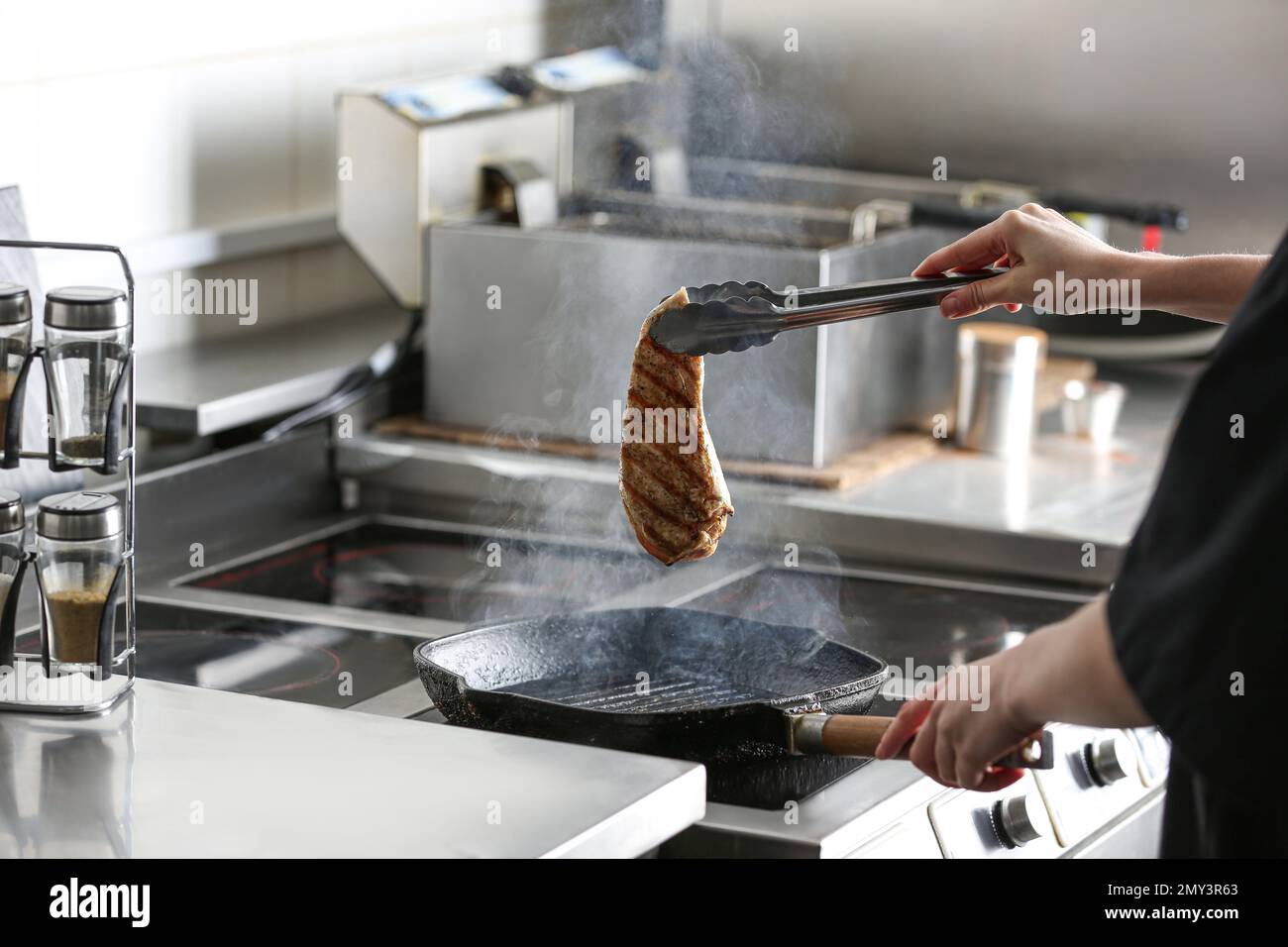Young woman cooking frying chicken hi-res stock photography and images ...