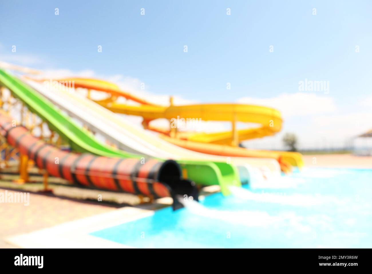 Different colorful slides in water park, blurred view Stock Photo - Alamy