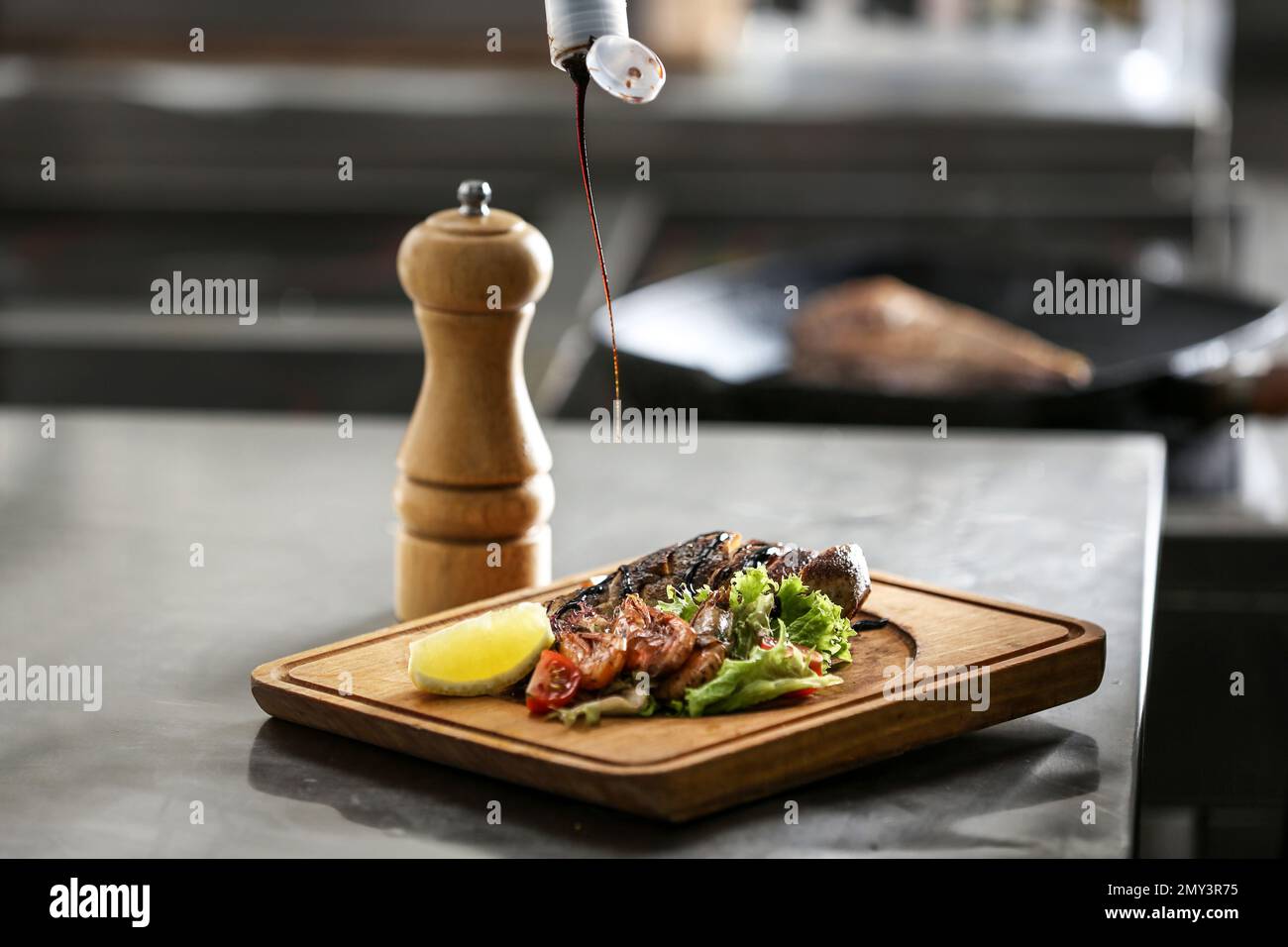 Adding sauce to tasty meal on table in restaurant kitchen. Cooking food ...