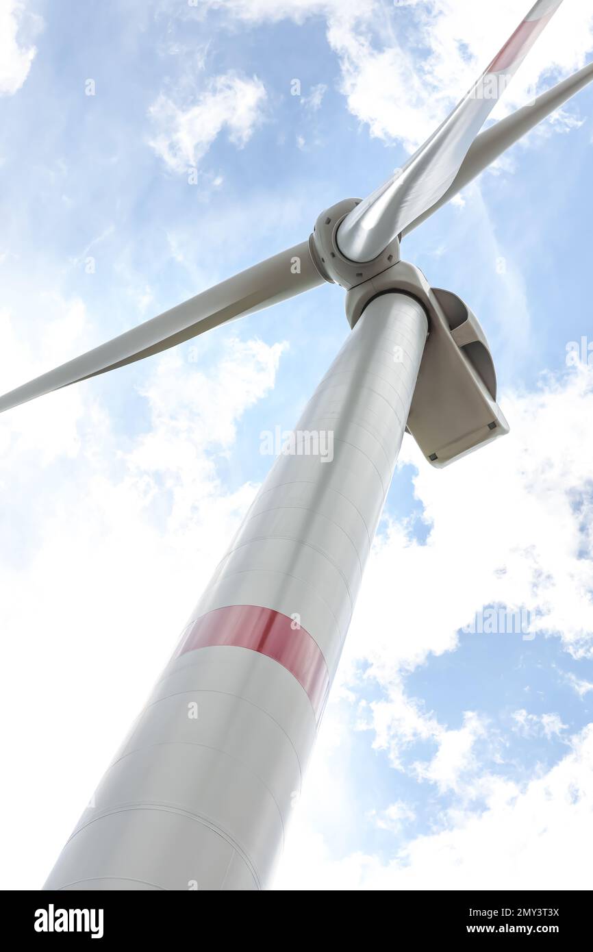 Modern wind turbine against cloudy sky, low angle view. Alternative ...