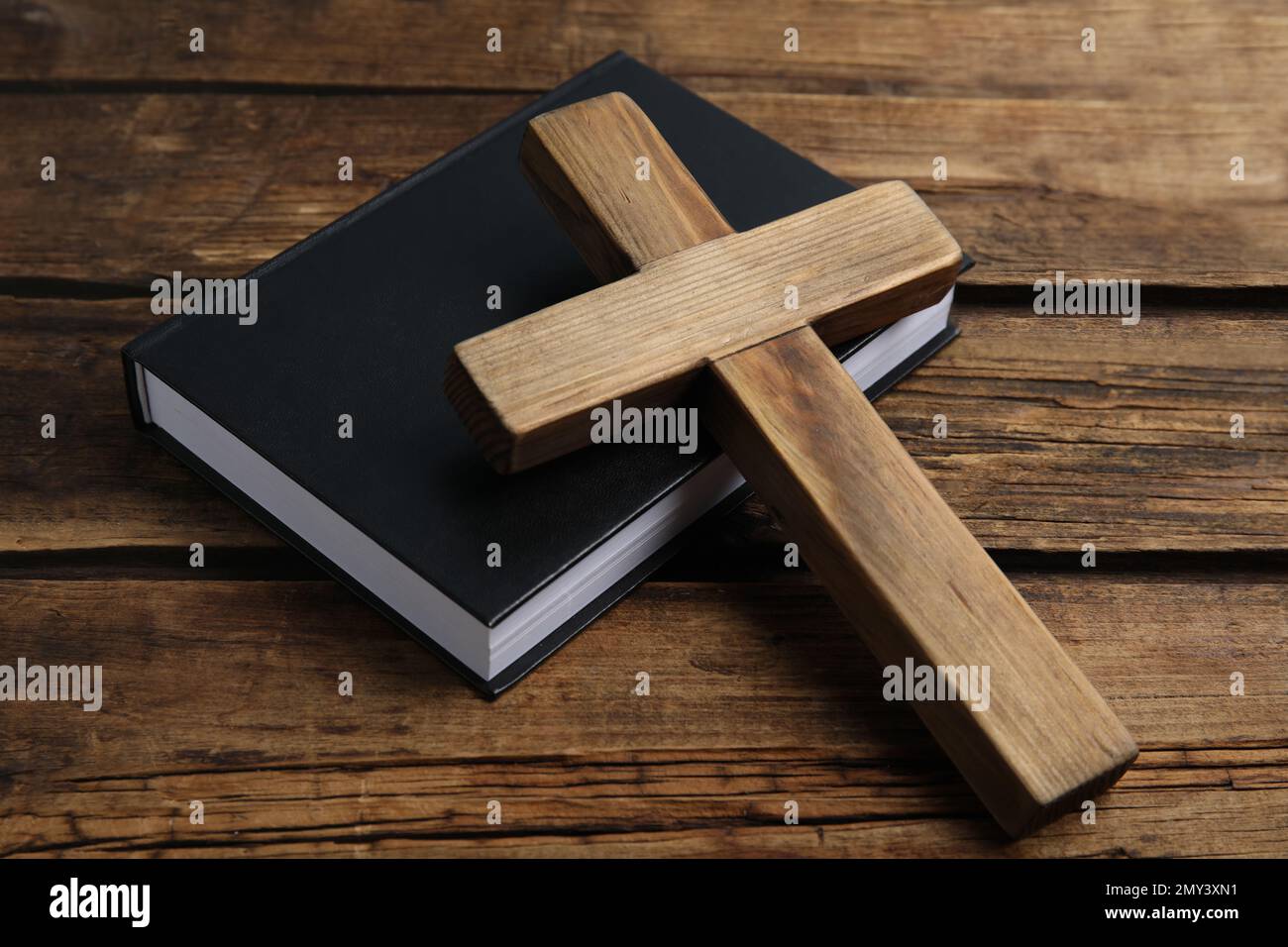 Christian cross and Bible on wooden background, closeup. Religion ...