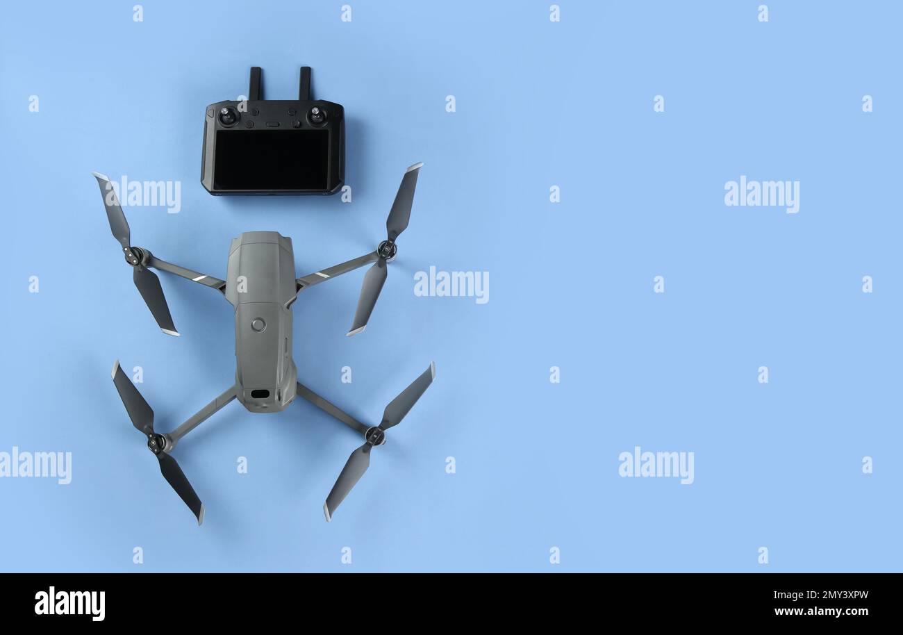 Modern drone with controller on blue background, flat lay. Space for ...