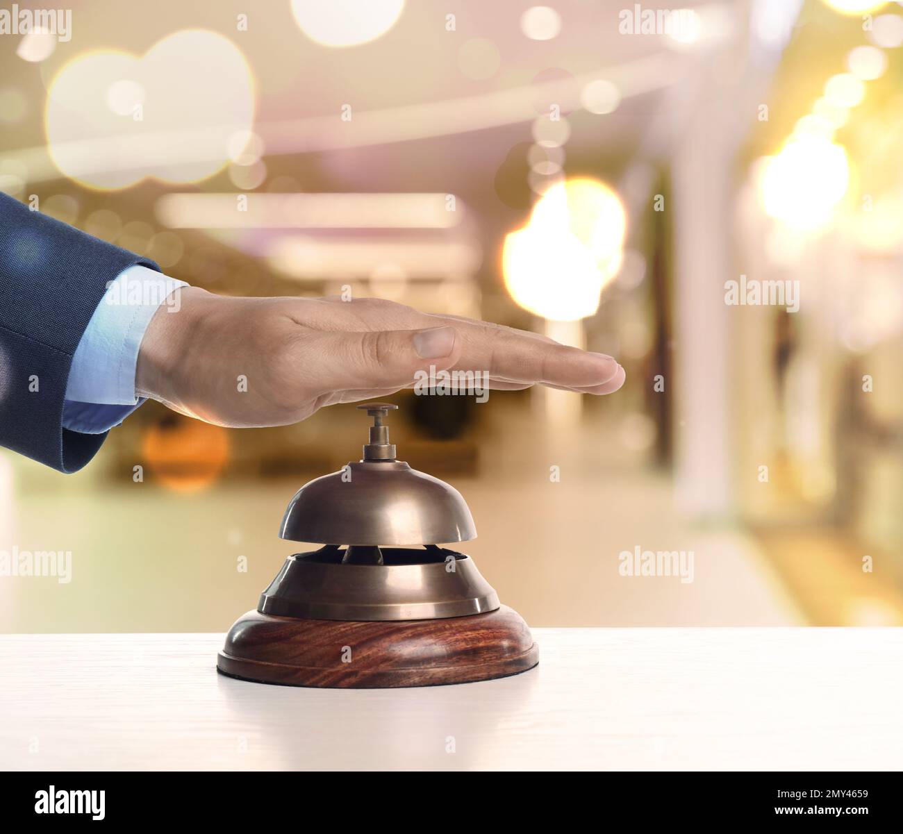 Man ringing hotel service bell on blurred background, closeup Stock ...