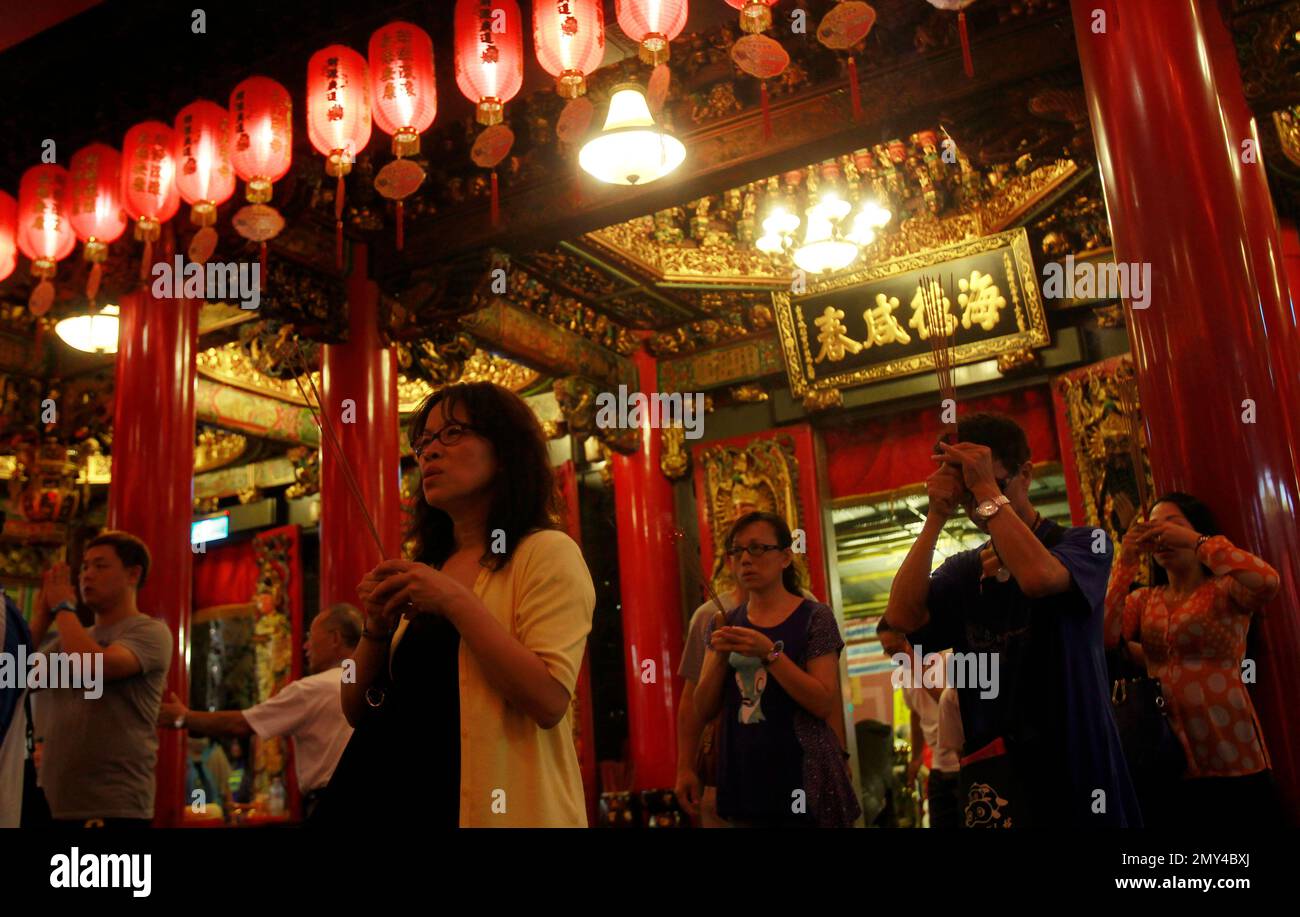 People pray during a ghost month ceremony in Taipei, Taiwan, Wednesday ...