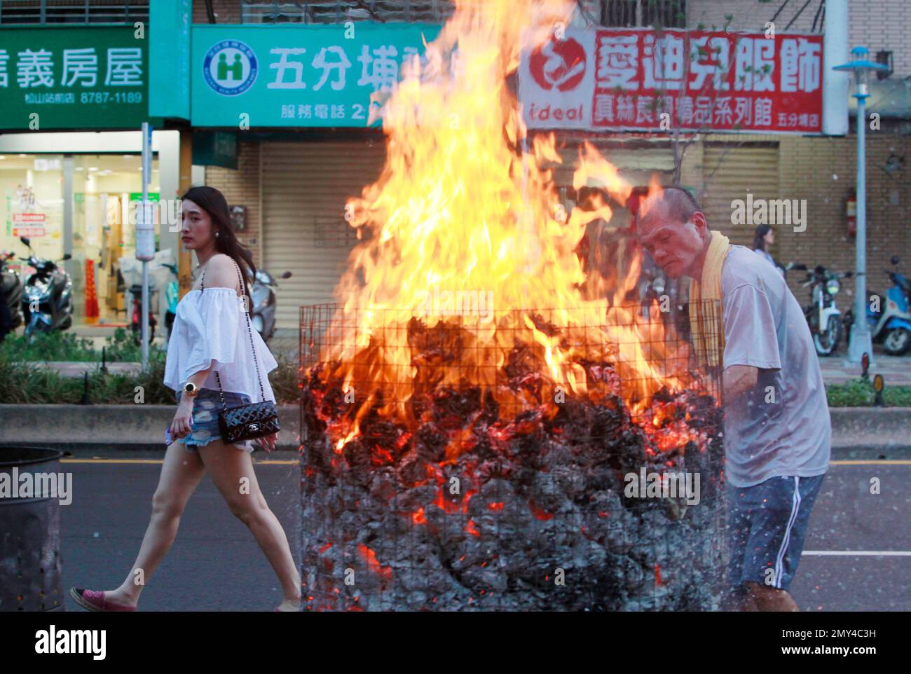 People burn ghost money during a ghost month ceremony in Taipei, Taiwan ...